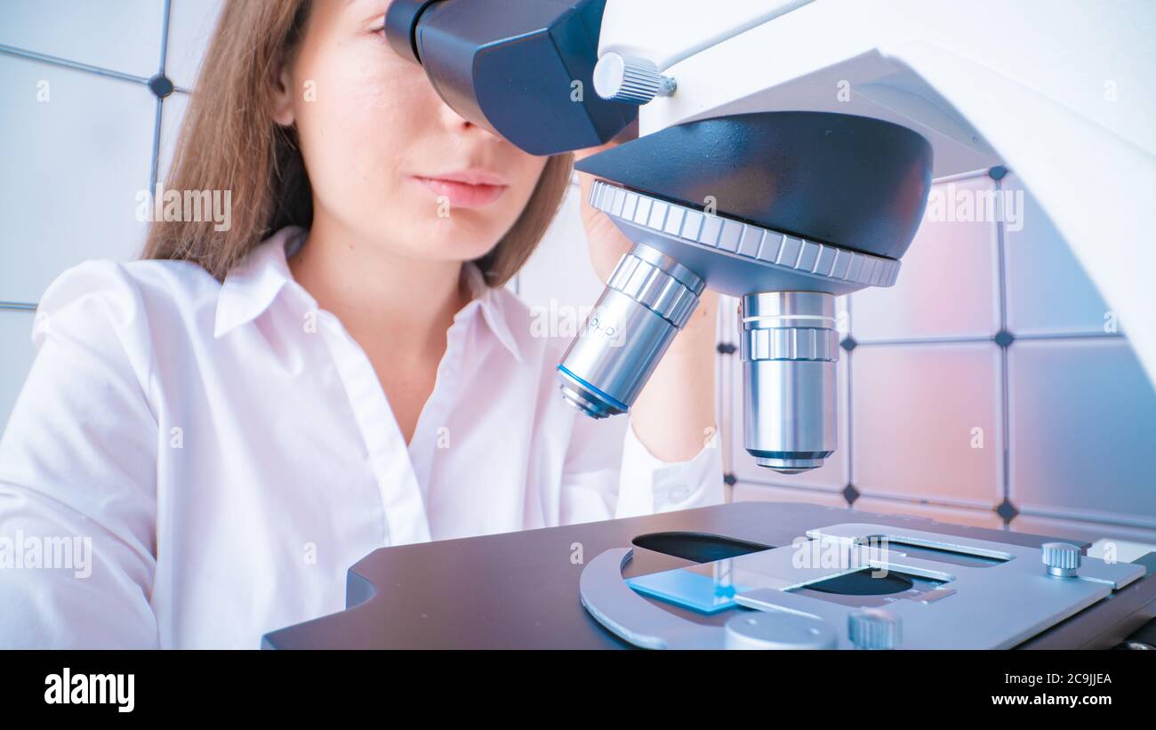 Researcher using microscope Stock Photo - Alamy