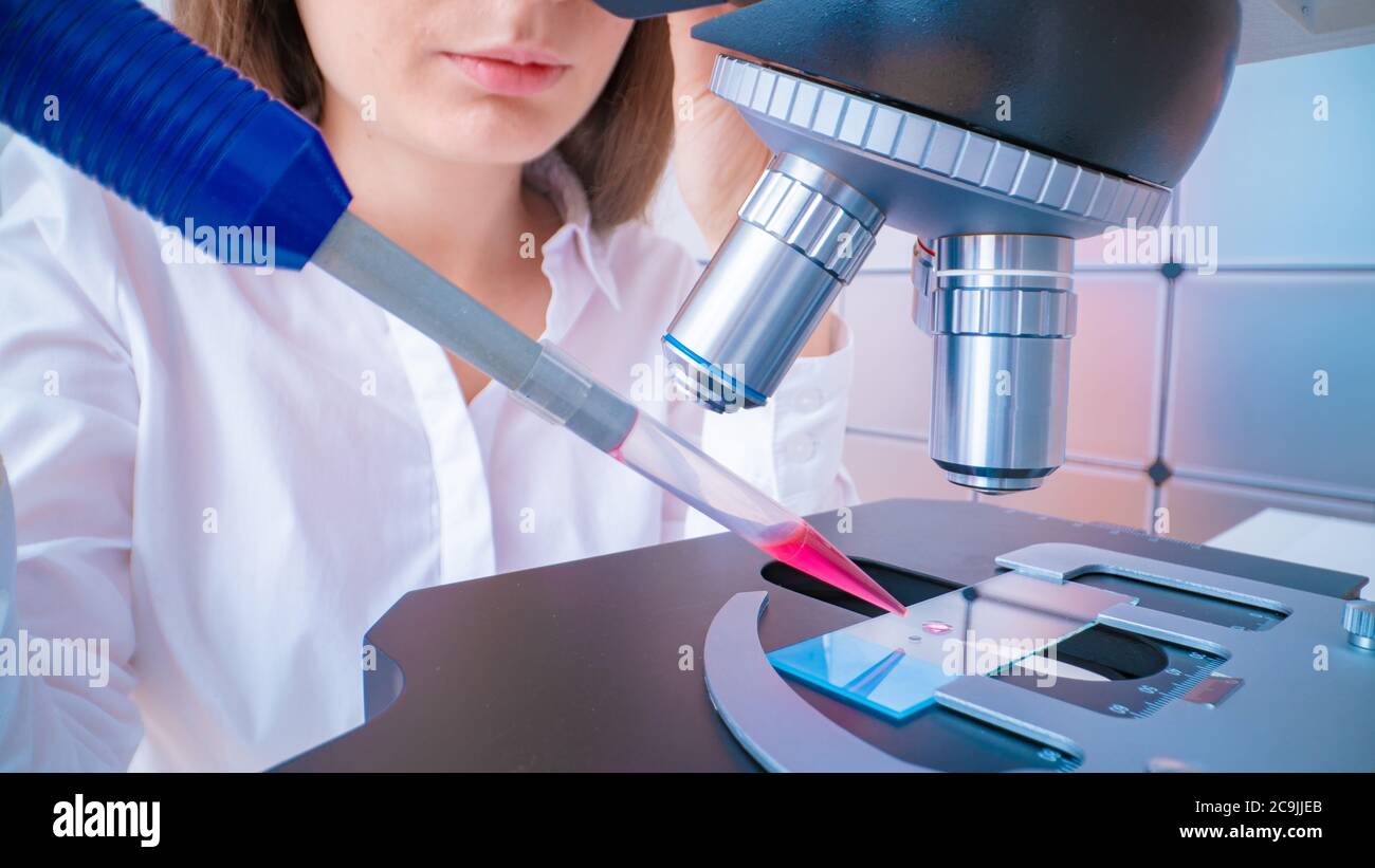 Doctor using microscope hi-res stock photography and images - Alamy