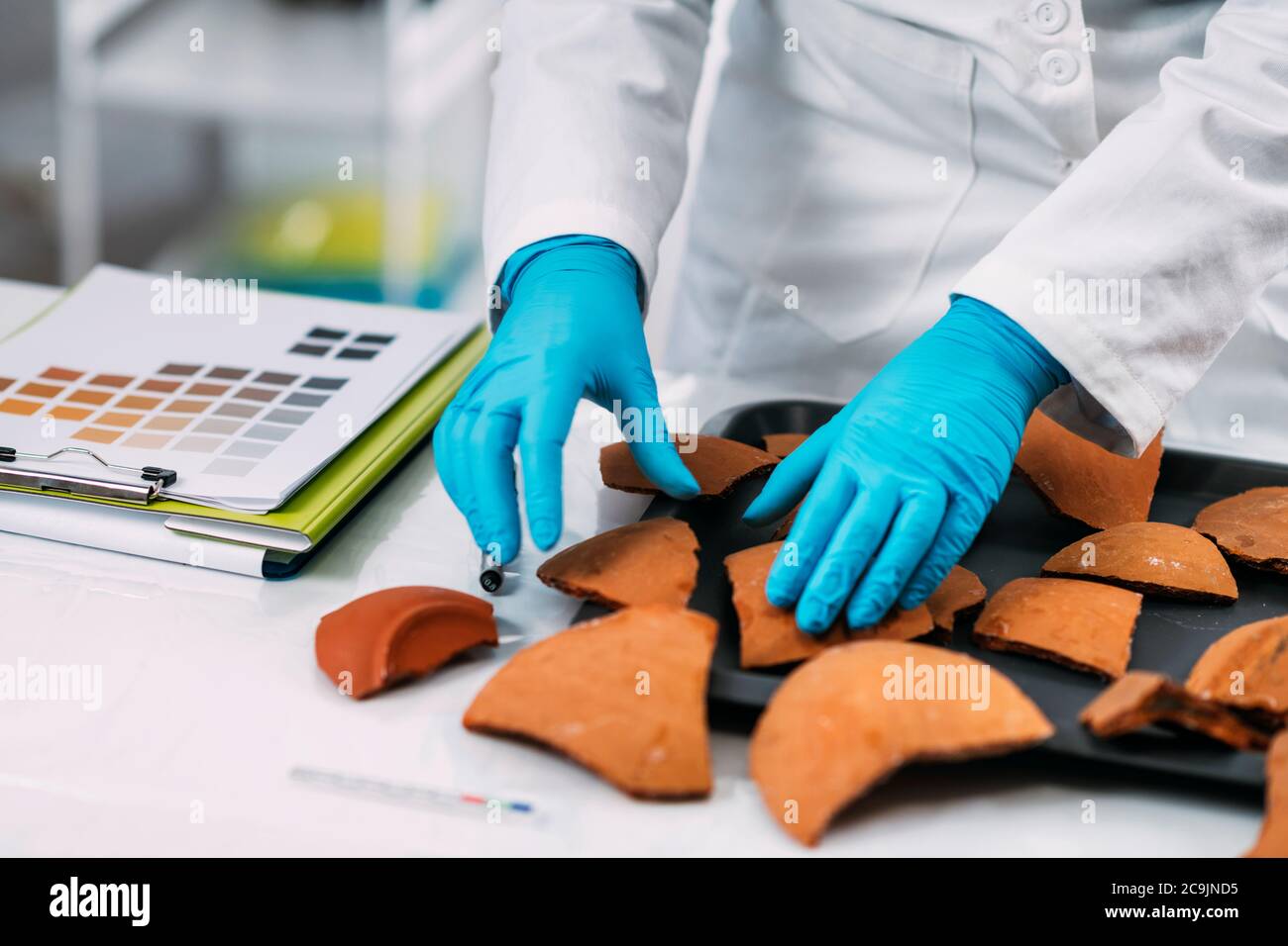 Archaeologists reconstructing broken pottery in laboratory Stock Photo ...