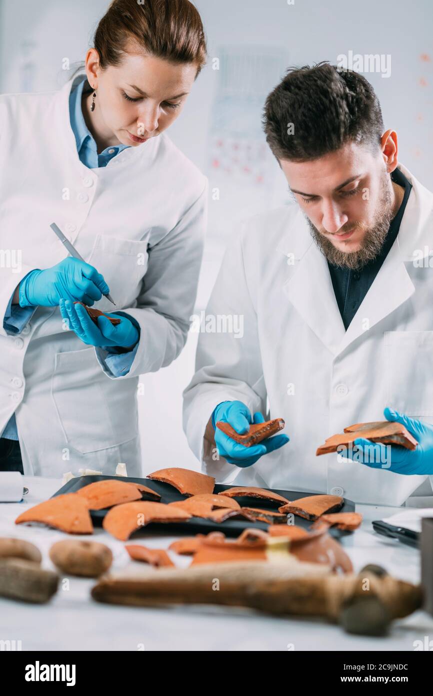 Archaeologists reconstructing broken pottery in laboratory Stock Photo ...