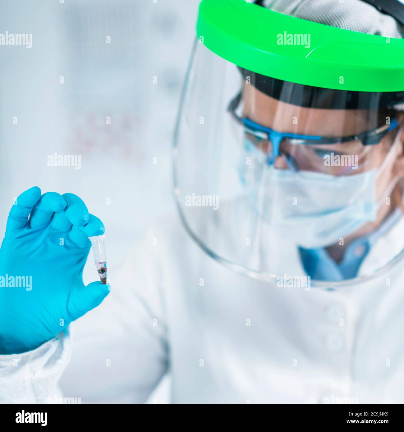 Ancient DNA analysis. Female scientist holding micro tube with sample ...