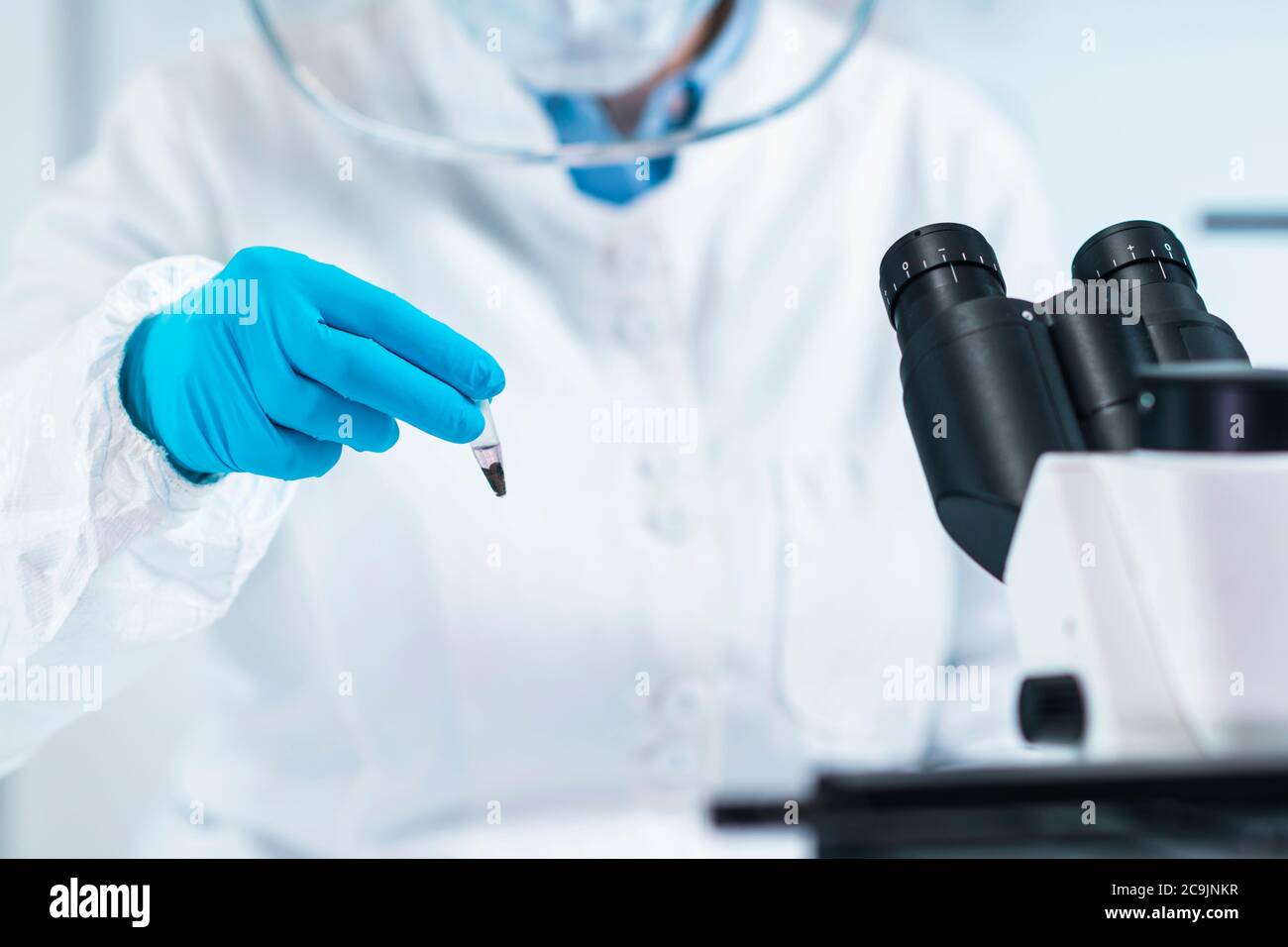Ancient DNA analysis. Female scientist holding micro tube with sample ...