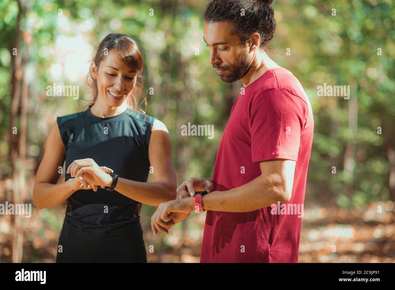 Young couple checking progress on their smart watches after outdoor ...