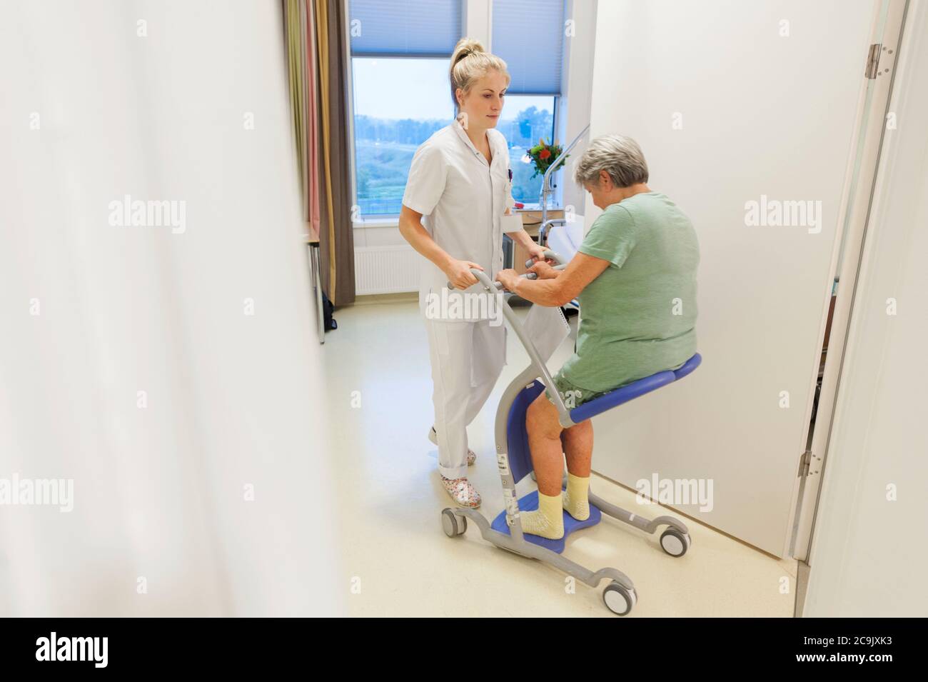 Geriatric hospital ward. Nurse helping a confused patient on the ...