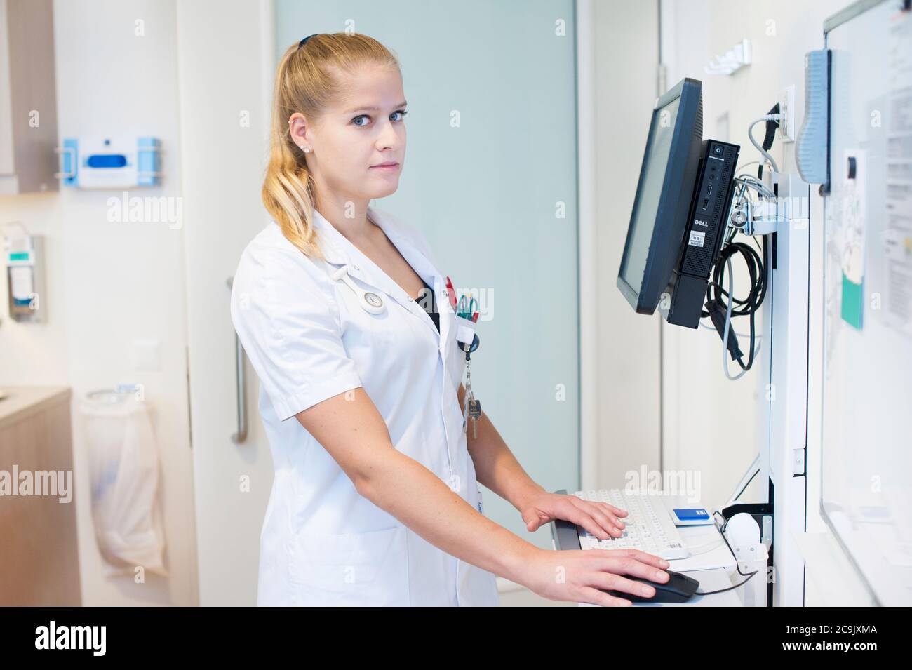Nurse at computer in a patient room Stock Photo - Alamy