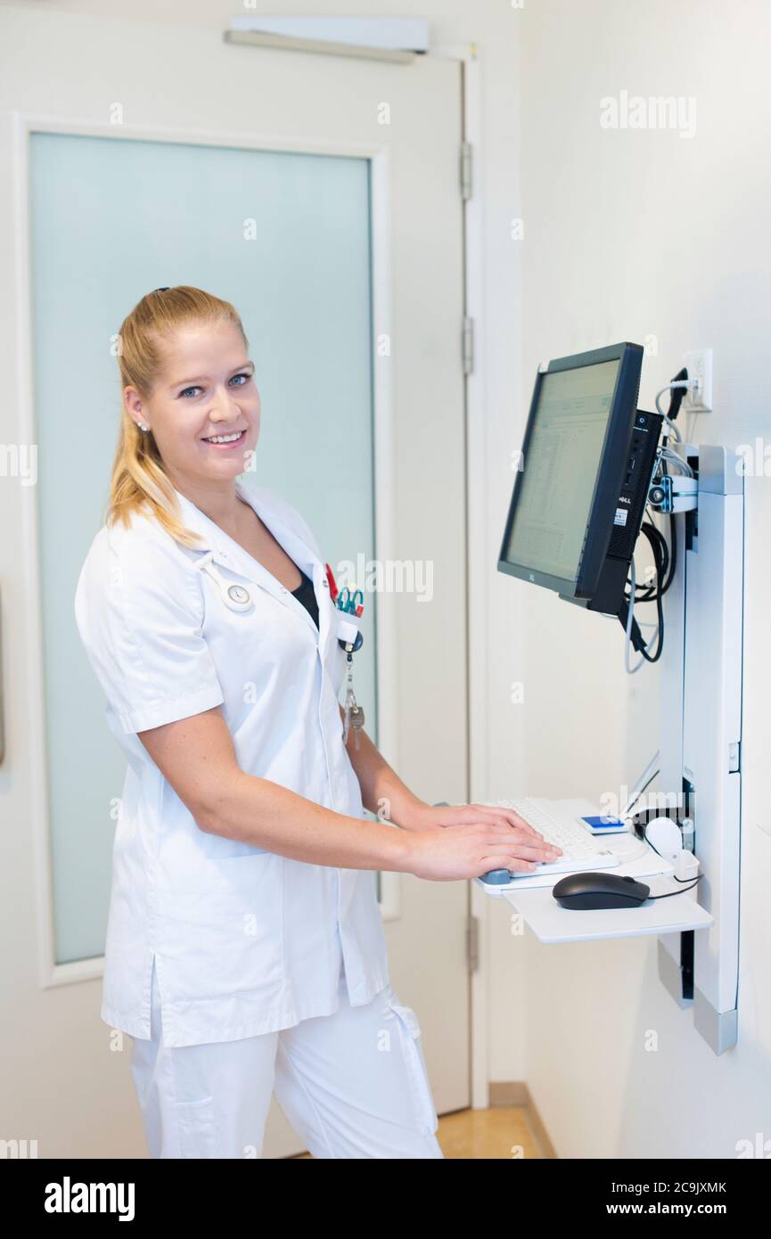 Nurse at computer in a patient room Stock Photo - Alamy