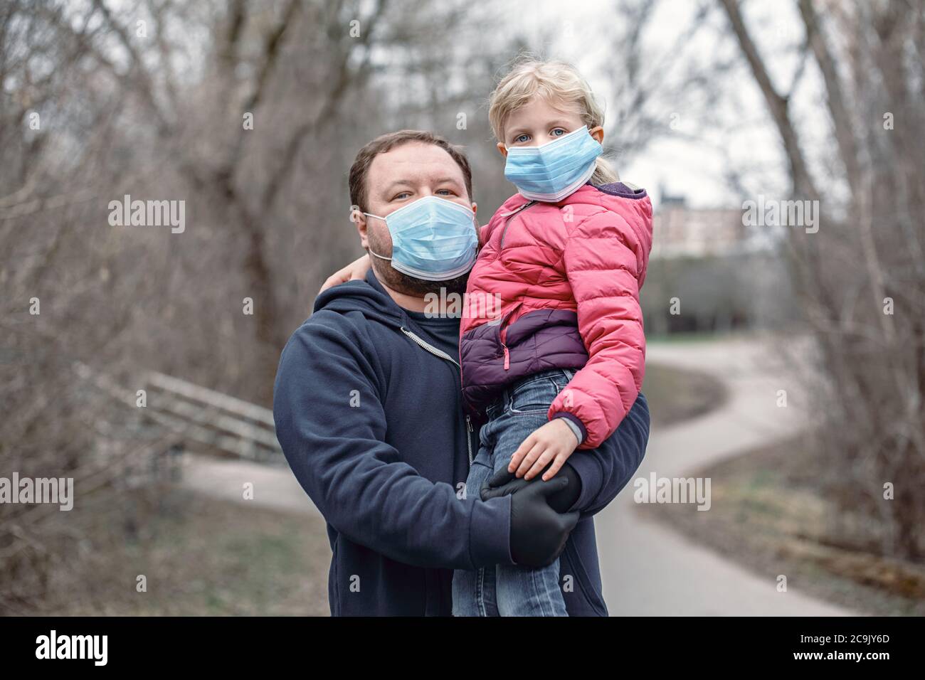 Caucasian father with child girl wearing sanitary face masks outdoor ...