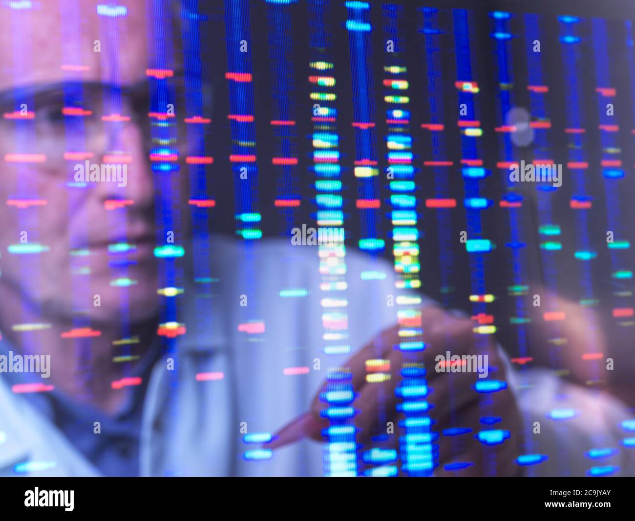 Scientist viewing DNA (deoxyribonucleic acid) profiles on a computer ...