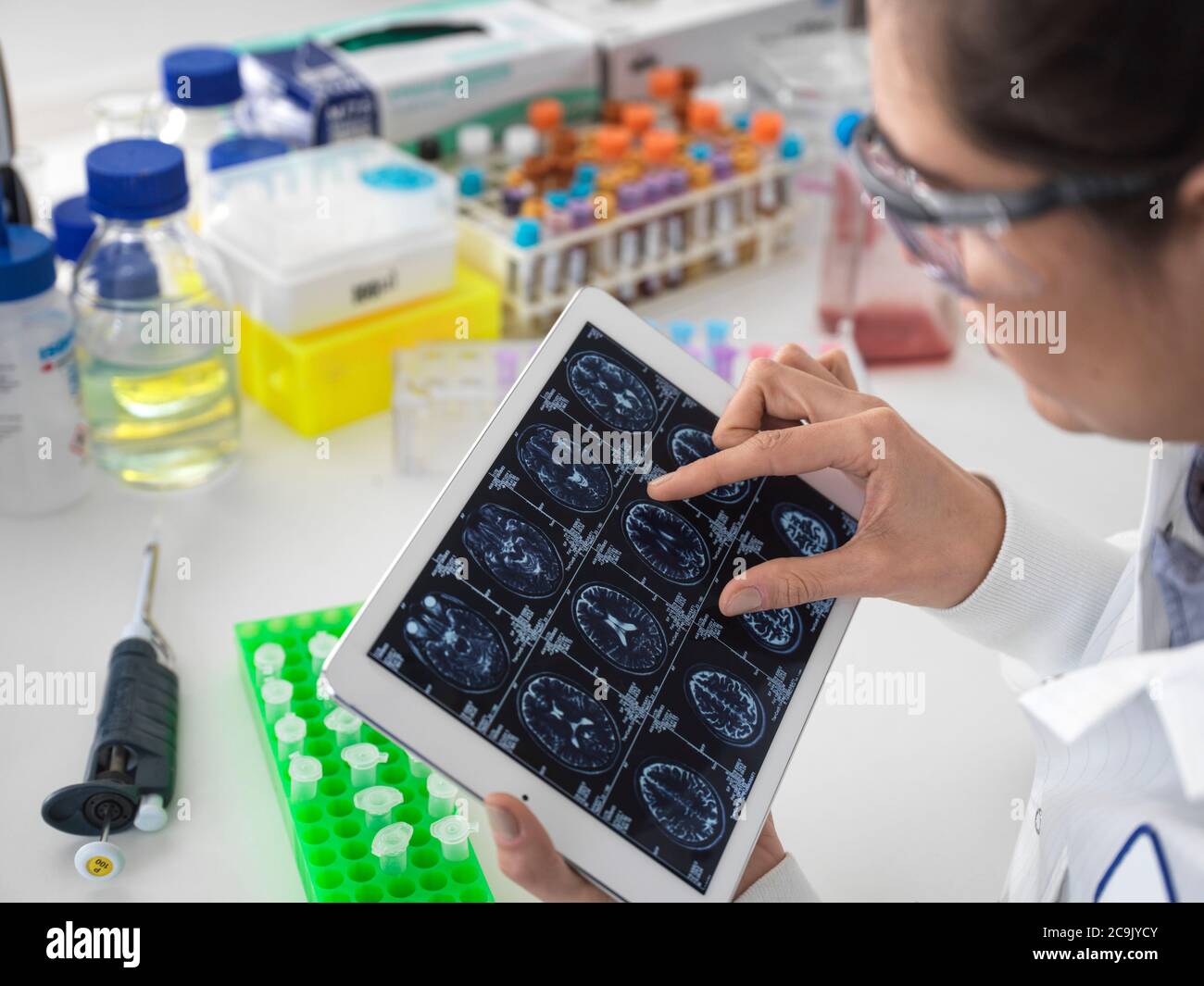 Scientist viewing a human brain scan on a touch screen during a ...