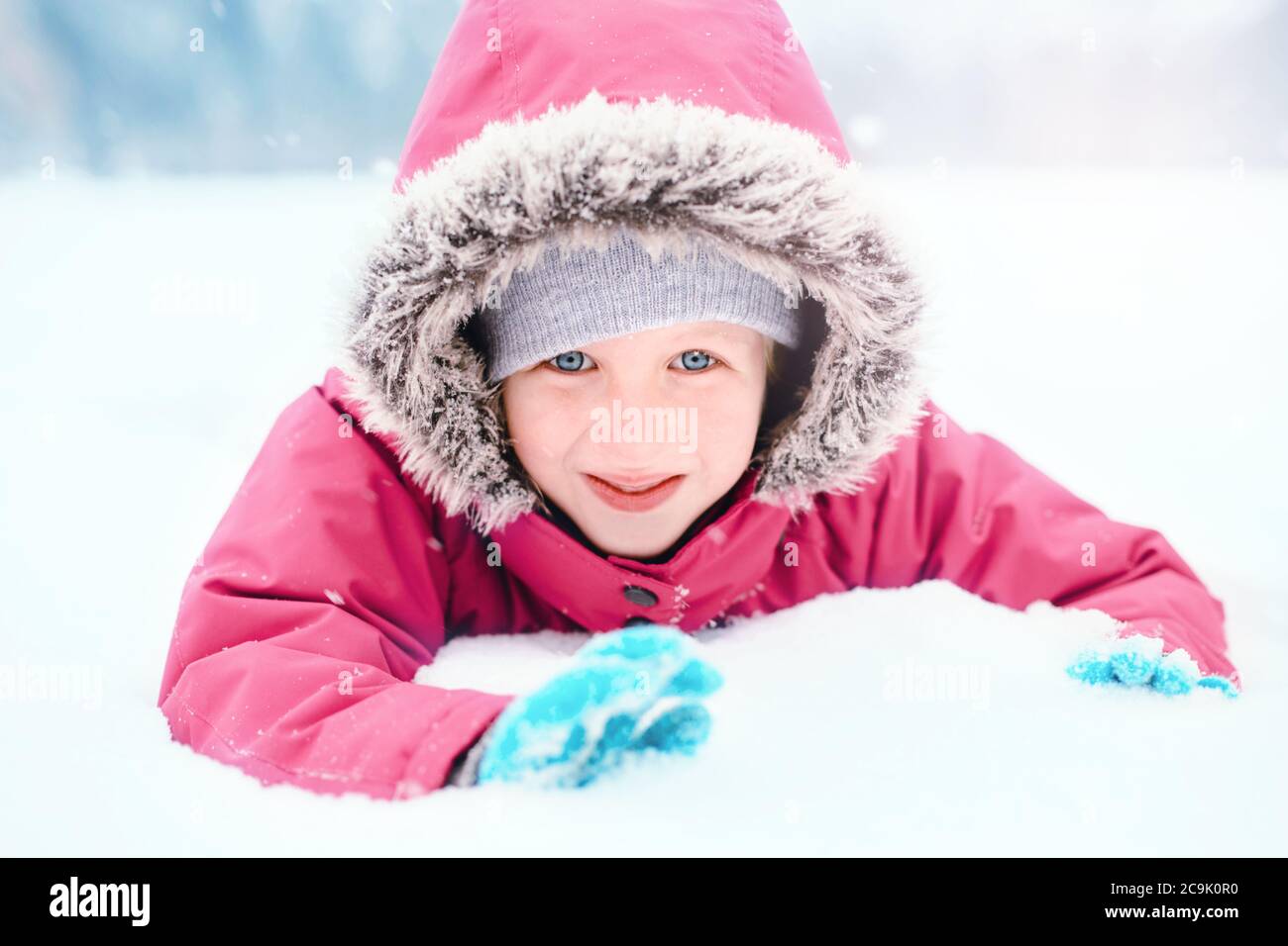 Cute Caucasian smiling excited girl child in pink jacket playing with ...