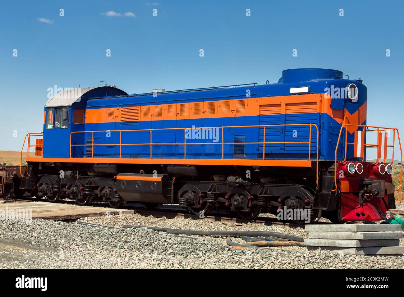 a blue shunting diesel locomotive with an orange stripe, a deck type ...