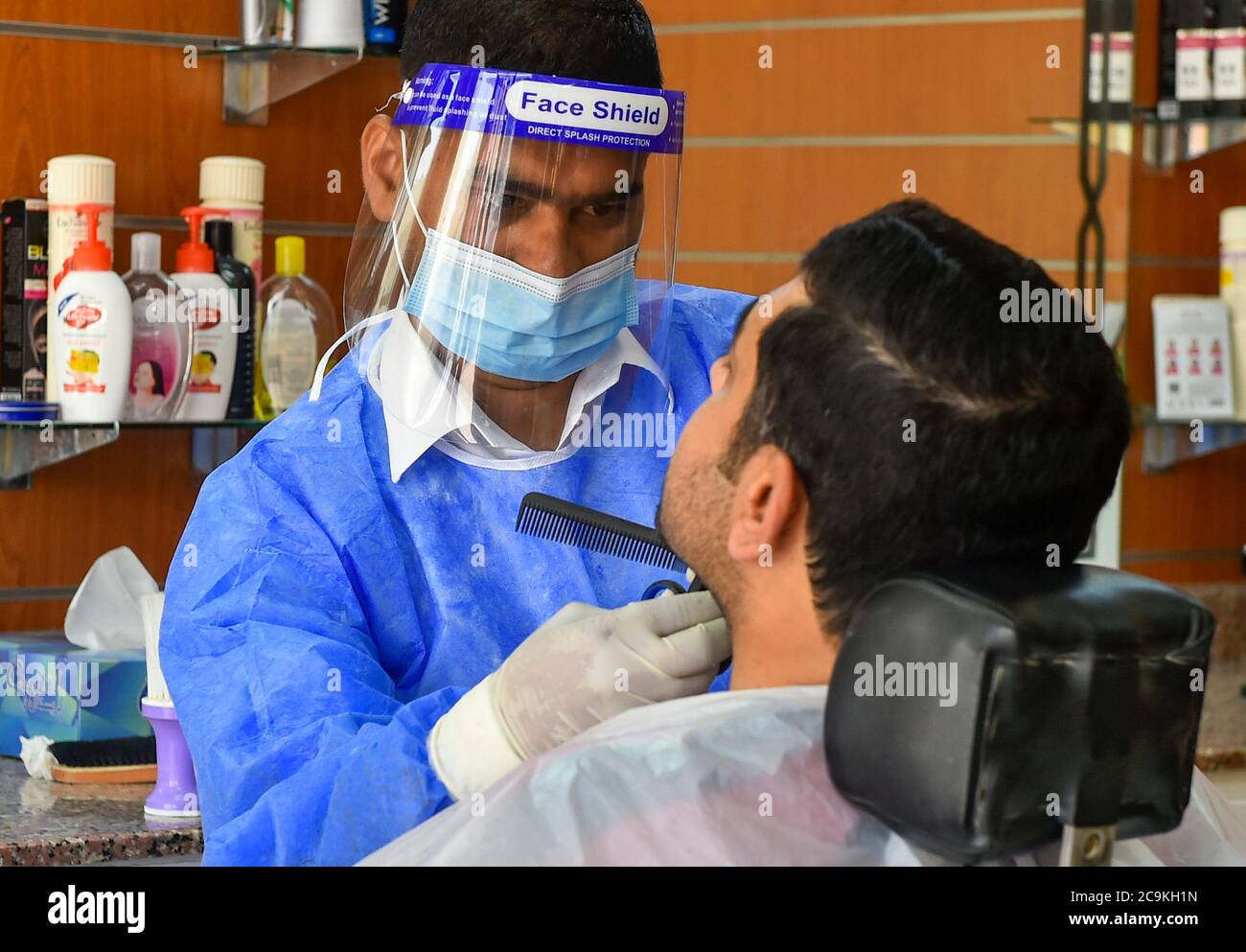 Doha, Qatar. 30th July, 2020. A barber wearing personal protective ...