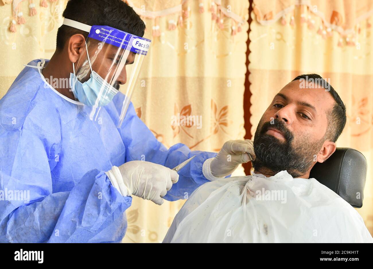 Doha, Qatar. 30th July, 2020. A barber wearing personal protective ...