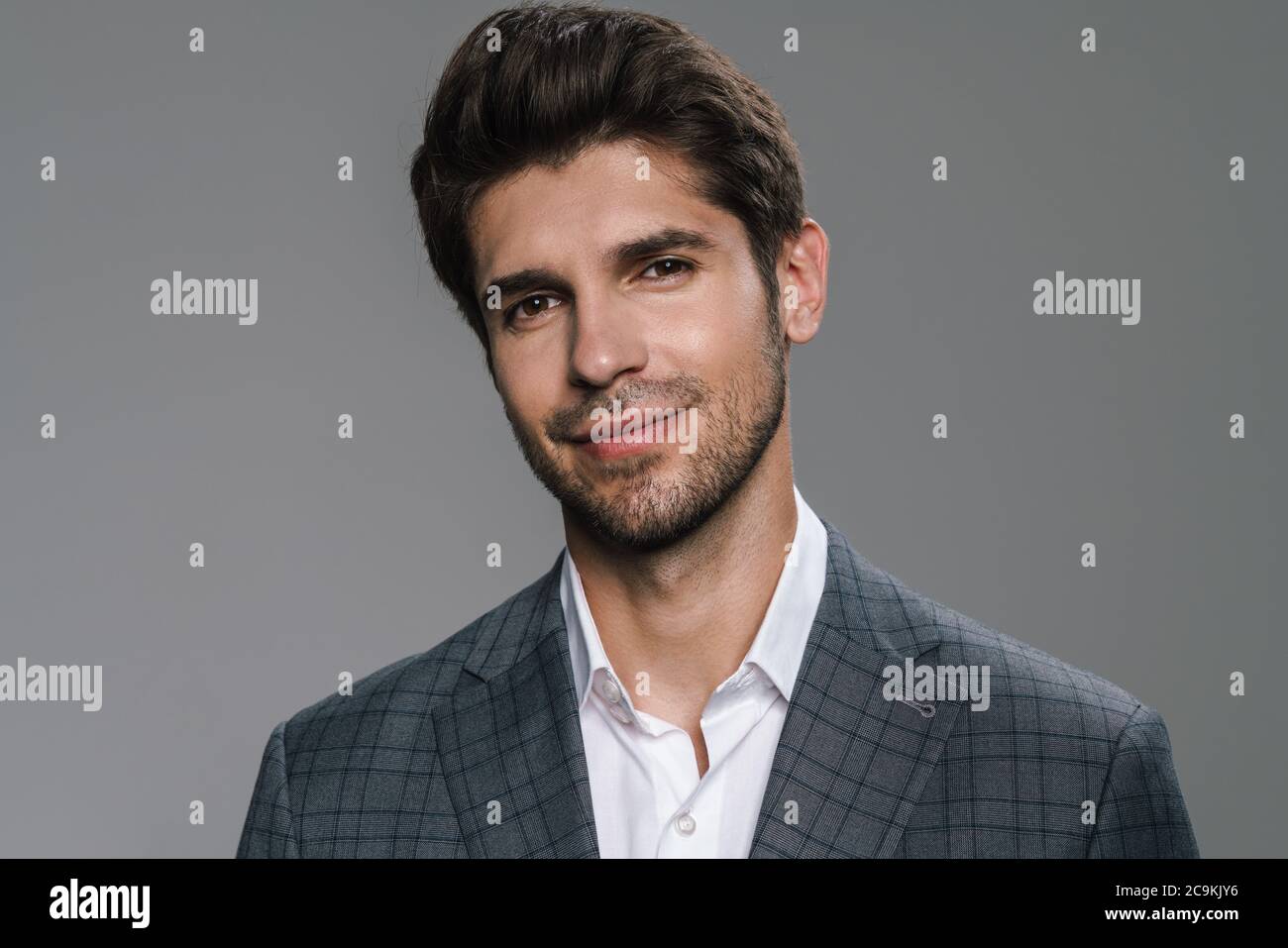 Photo of pleased businessman in jacket posing and smiling at camera ...