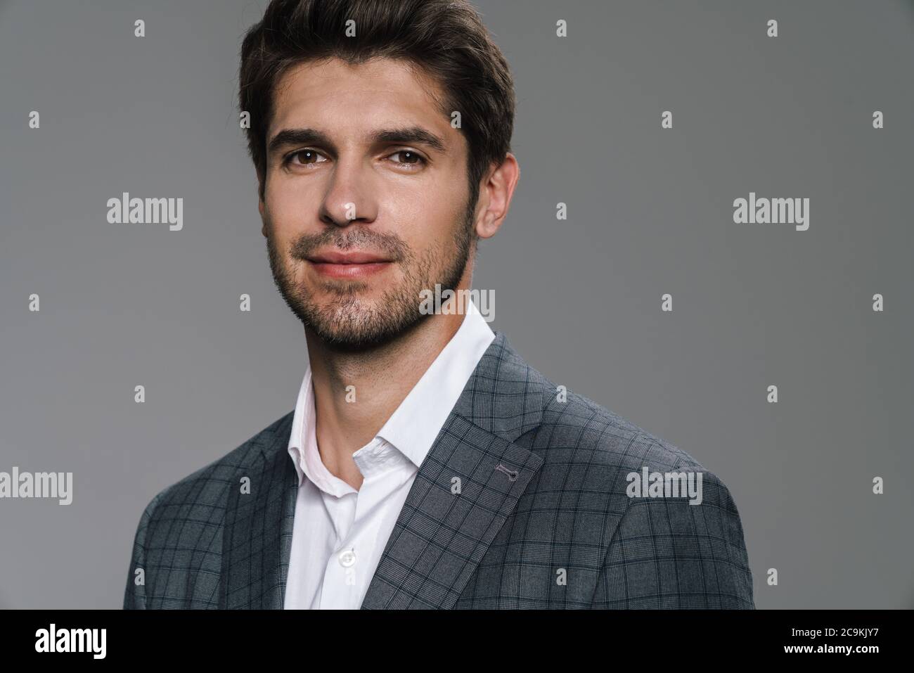 Photo of pleased businessman in jacket posing and smiling at camera ...