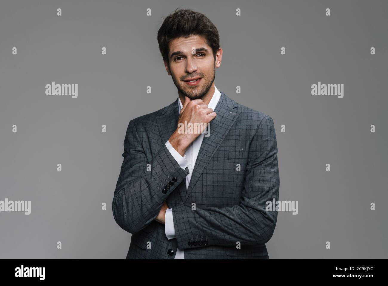 Photo of pleased businessman in jacket posing and smiling at camera ...