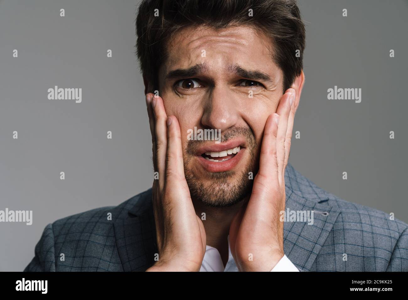 Photo Of Unshaven Shocked Businessman In Jacket Expressing Surprise On