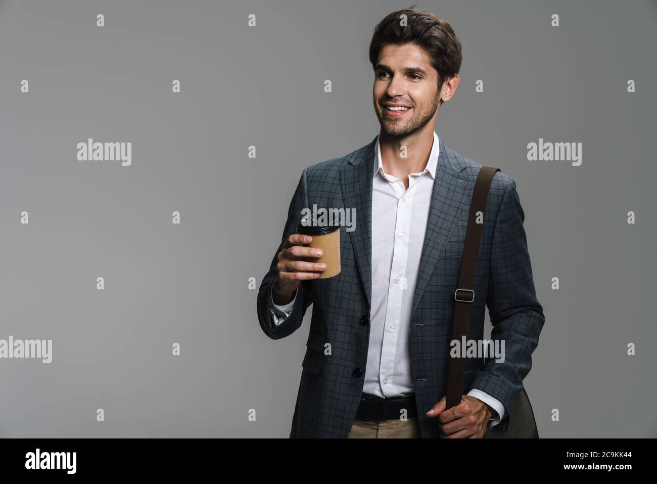 Photo of smiling confident businessman with bag drinking coffee ...