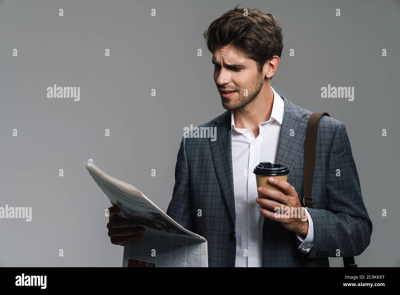 Photo of confused businessman drinking coffee takeaway while reading ...