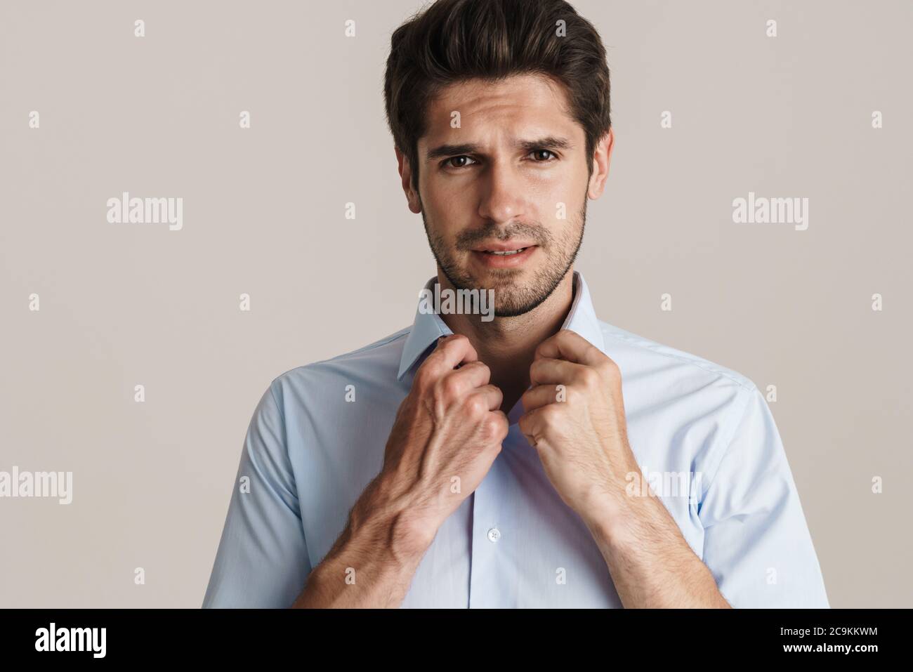 Portrait of unshaven displeased man posing and looking at camera ...