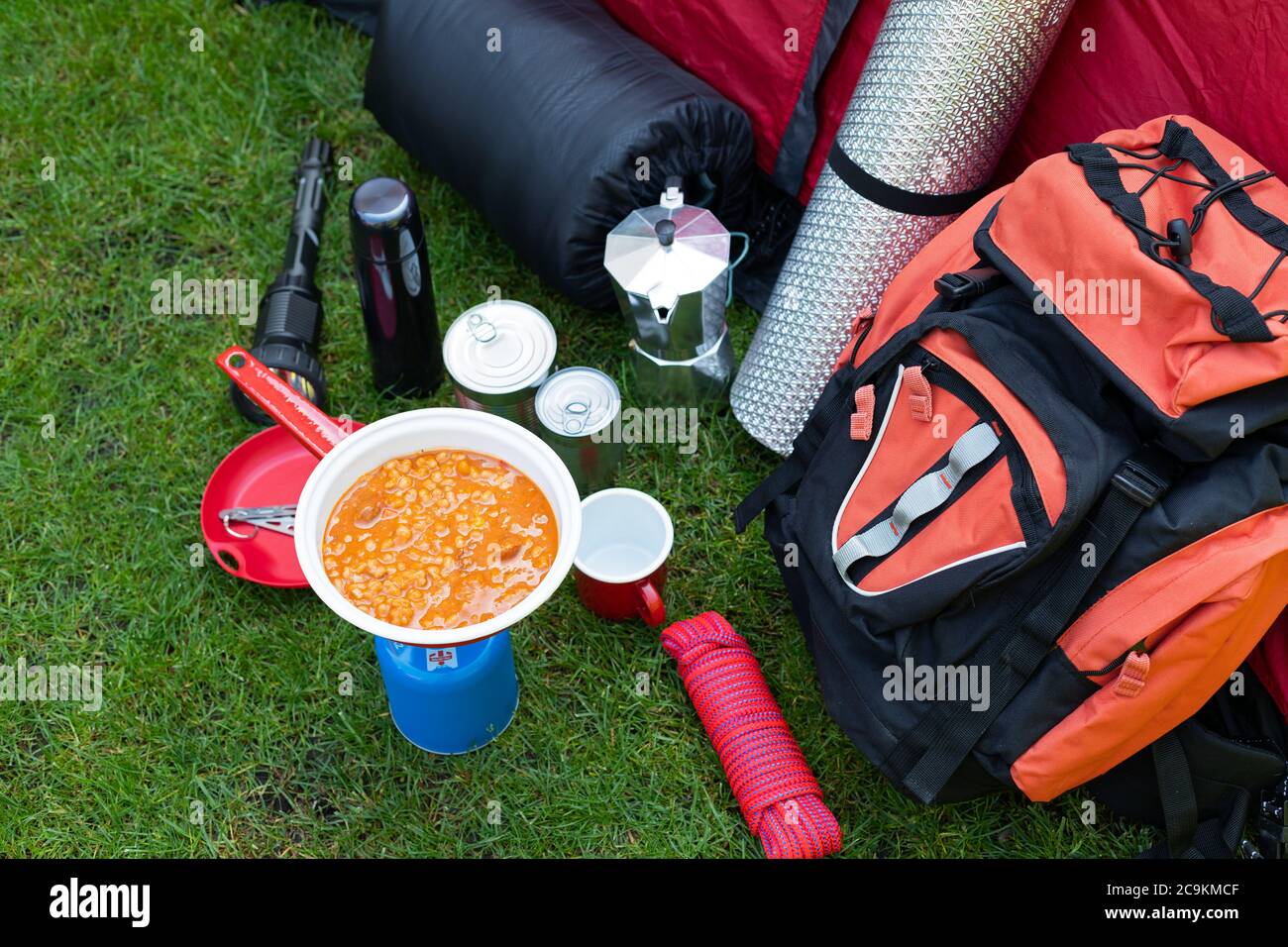 Picture of camping tools on the grass - backpack, tent, gas tank, cans ...