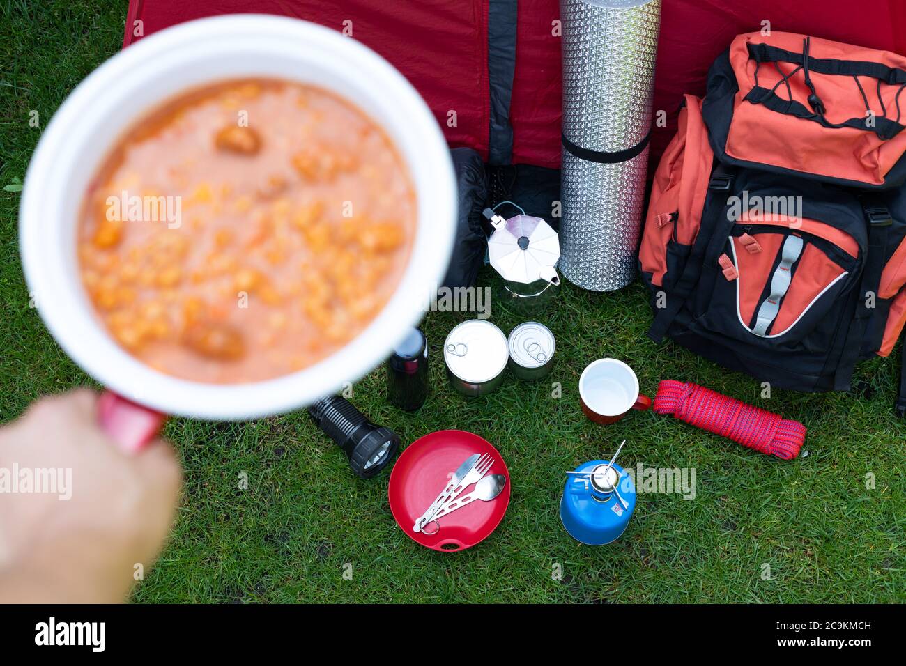 Picture of camping tools on the grass - backpack, tent, gas tank, cans ...