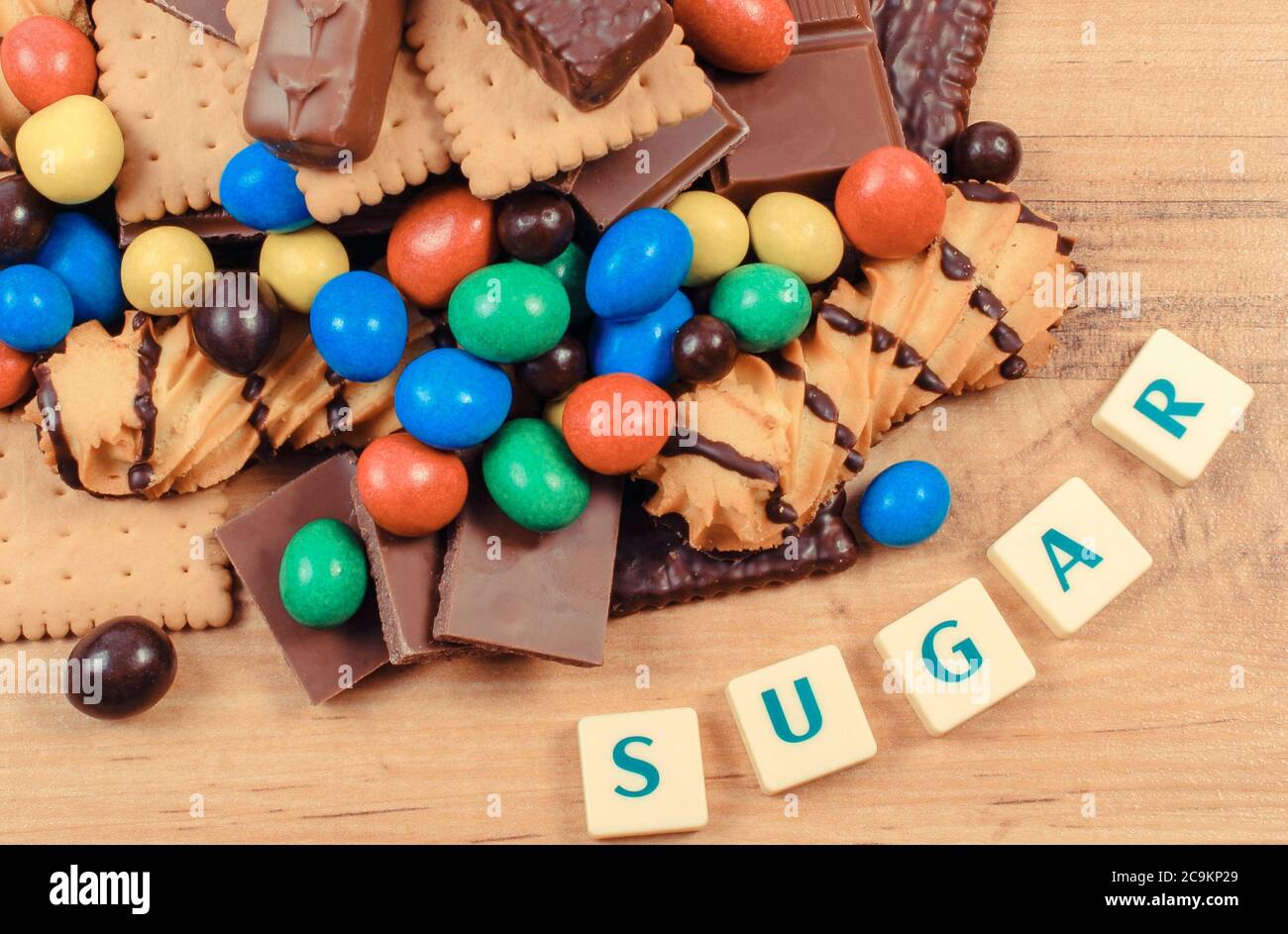 Granulated natural brown cane sugar and candies with cookies. Unhealthy ...