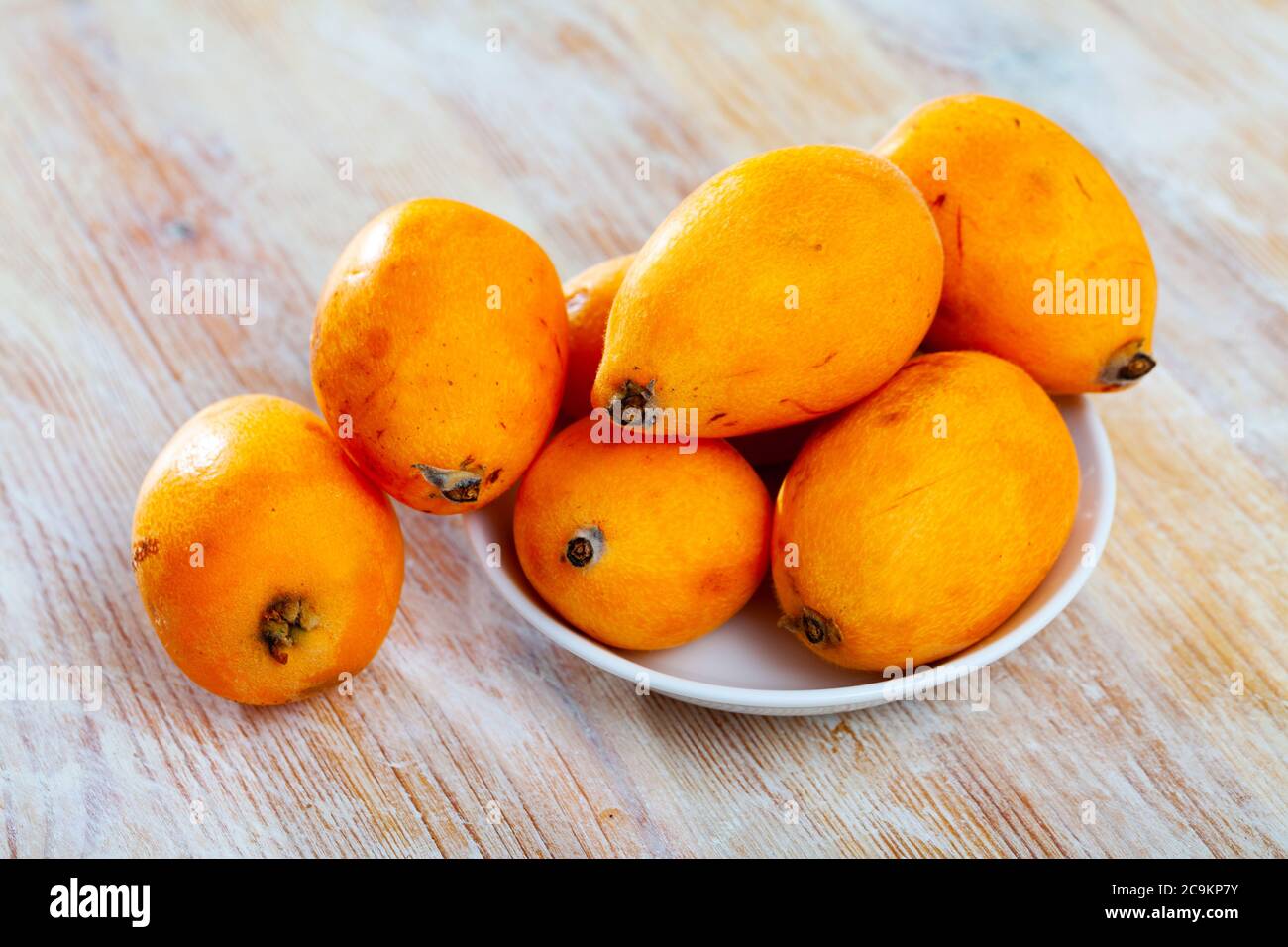Fresh yellow loquat fruits on wooden surface. Spring vitamin product ...