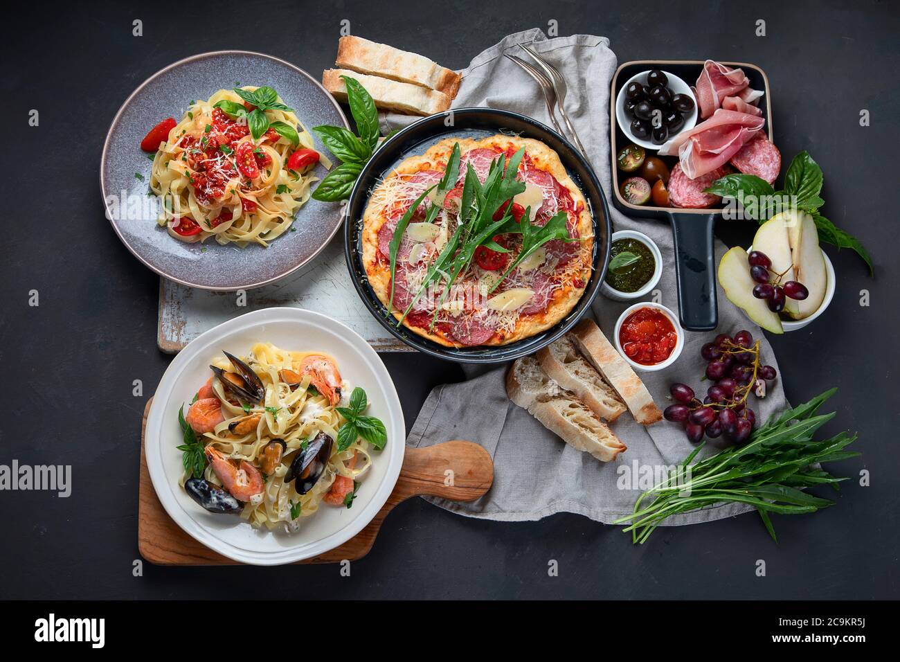 Italian food on dark background with pasta, pizza, top view Stock Photo ...