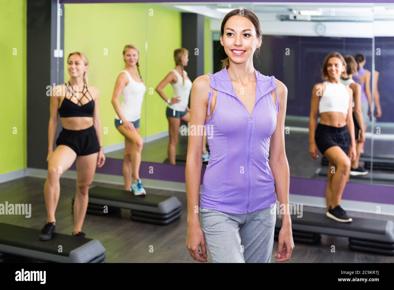 Smiling cheerful positive athletic girl during workout with step ...
