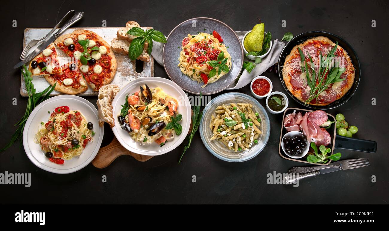 Italian food on dark background with pasta, pizza, top view Stock Photo ...