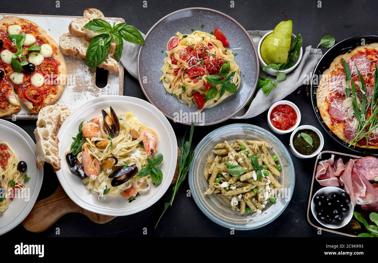Italian food on dark background with pasta, pizza, top view Stock Photo ...