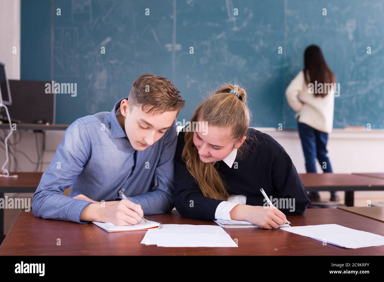 Two teenage students studying together in classroom. Education concept ...