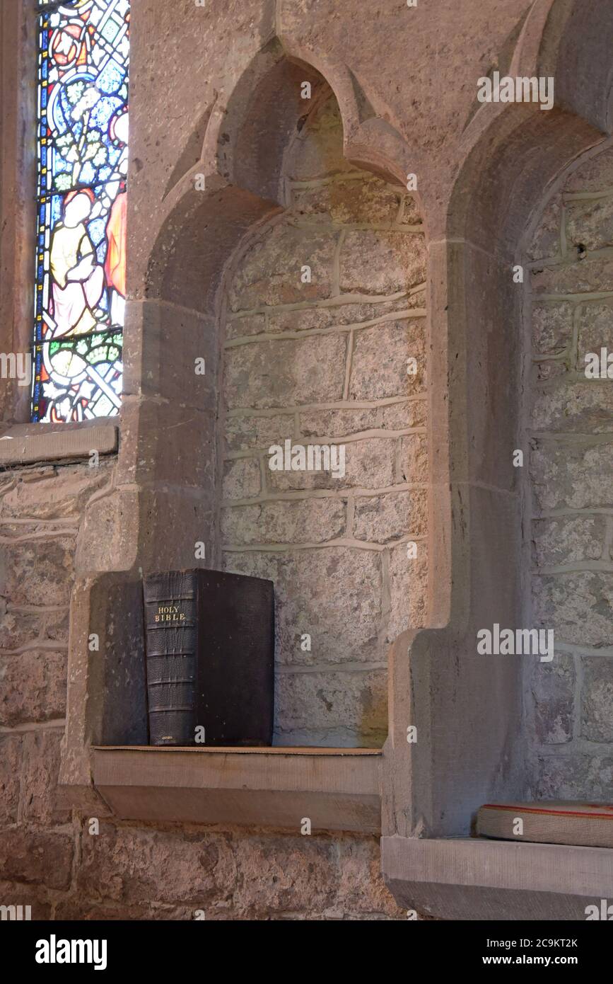 A sedilia,or stone seat for a priest with an old bible resting in it ...