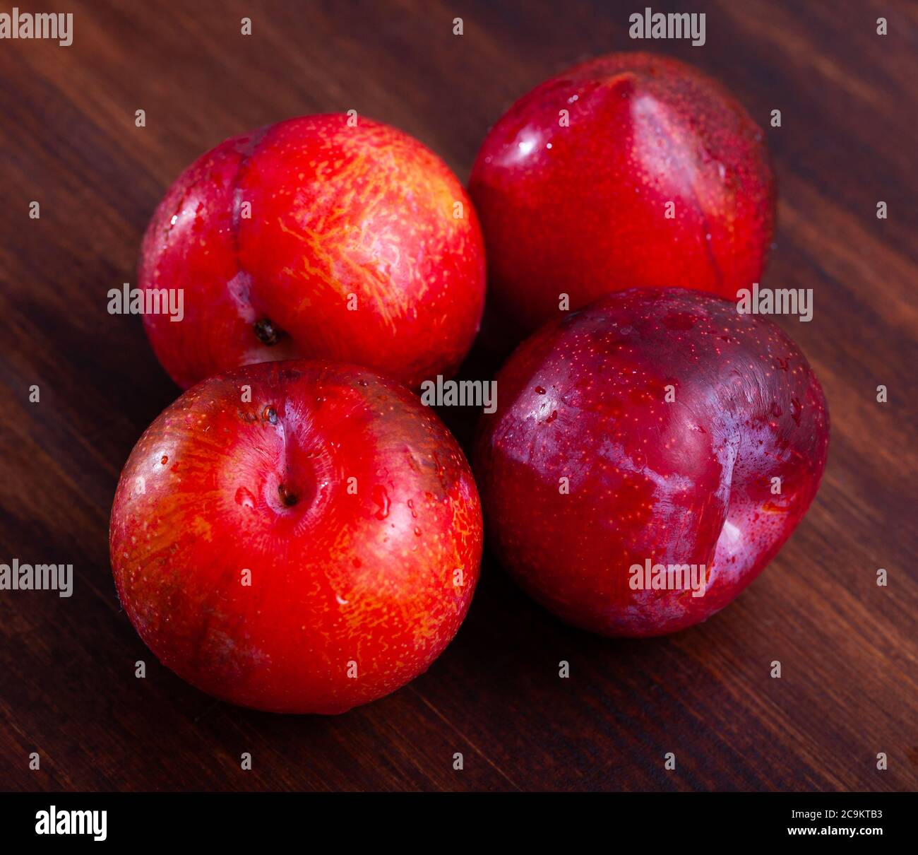 Fresh sweet red plums on wooden surface. Concept of health benefits of ...