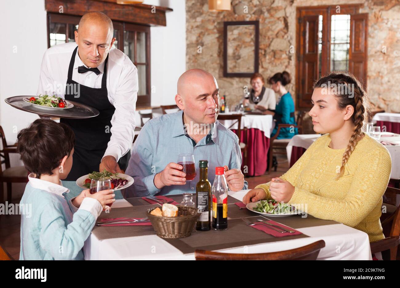Cheerful waiter serving plates hi-res stock photography and images - Alamy