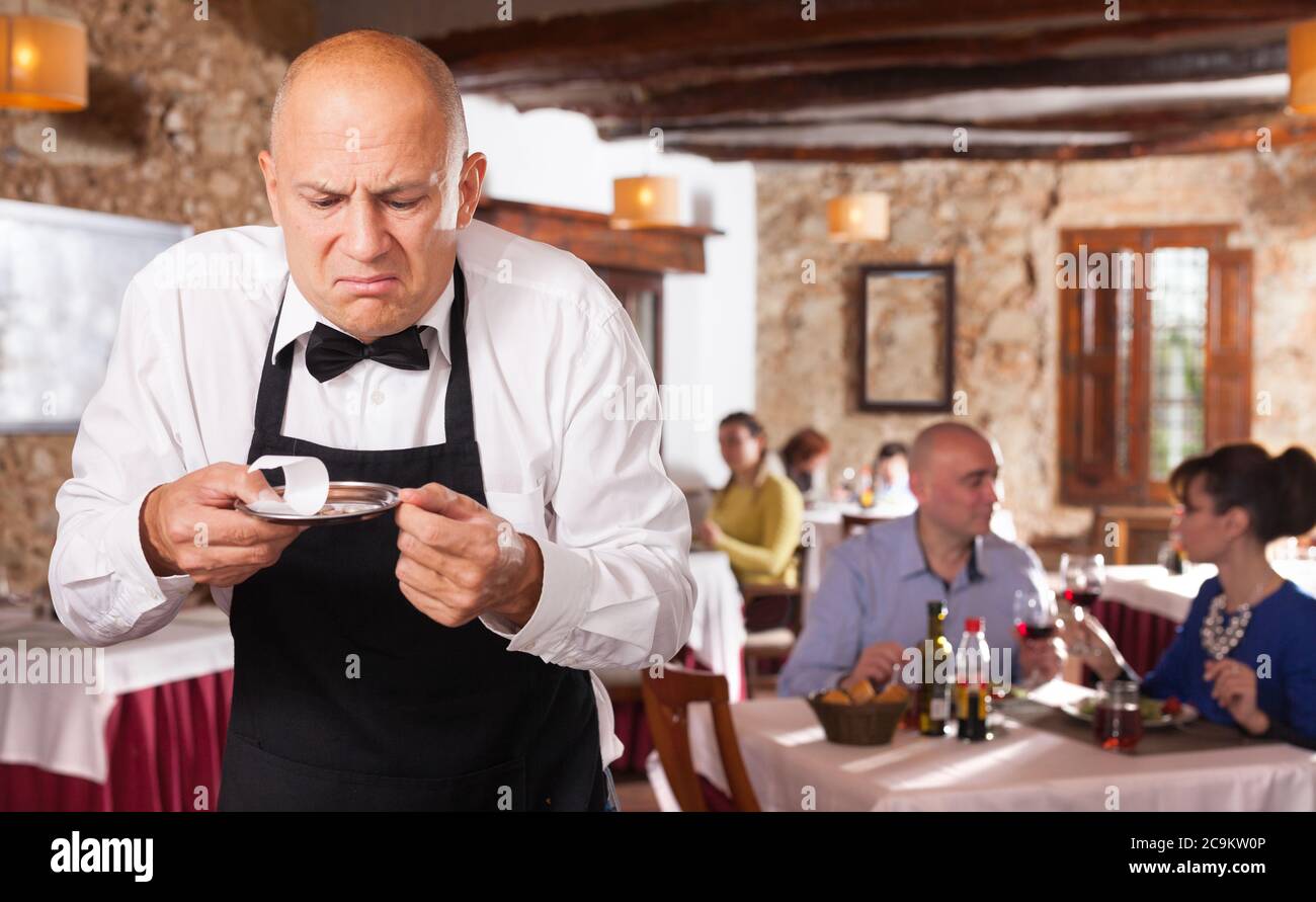 Male waiter demonstrating his upset with little tips from restaurant ...