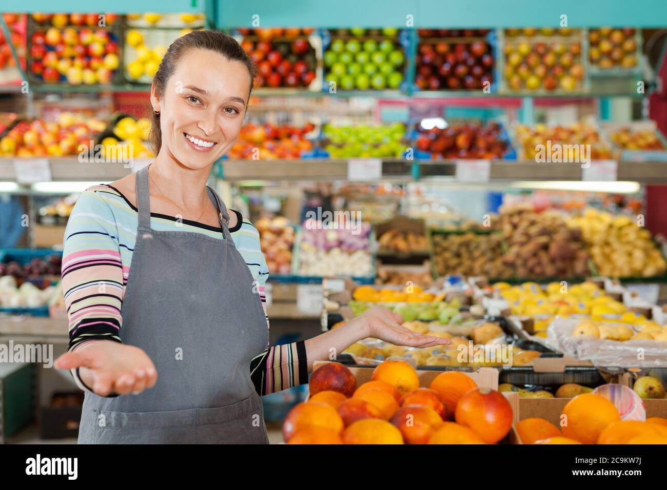 Happy cheerful positive Caucasian female store employee at fruit ...