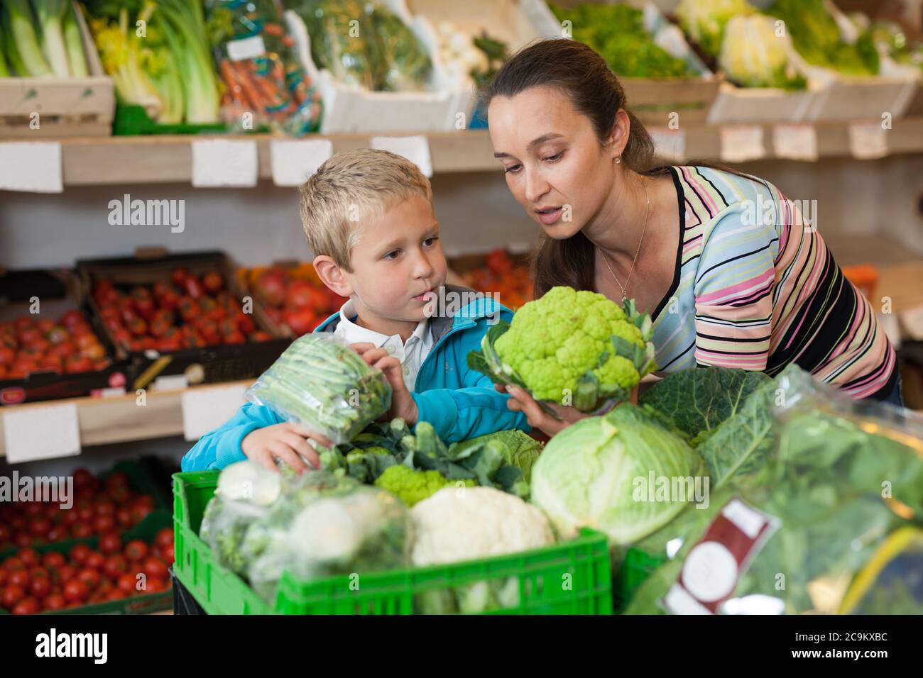 Cheerful mother with little boy buying broccoli at store Stock Photo ...