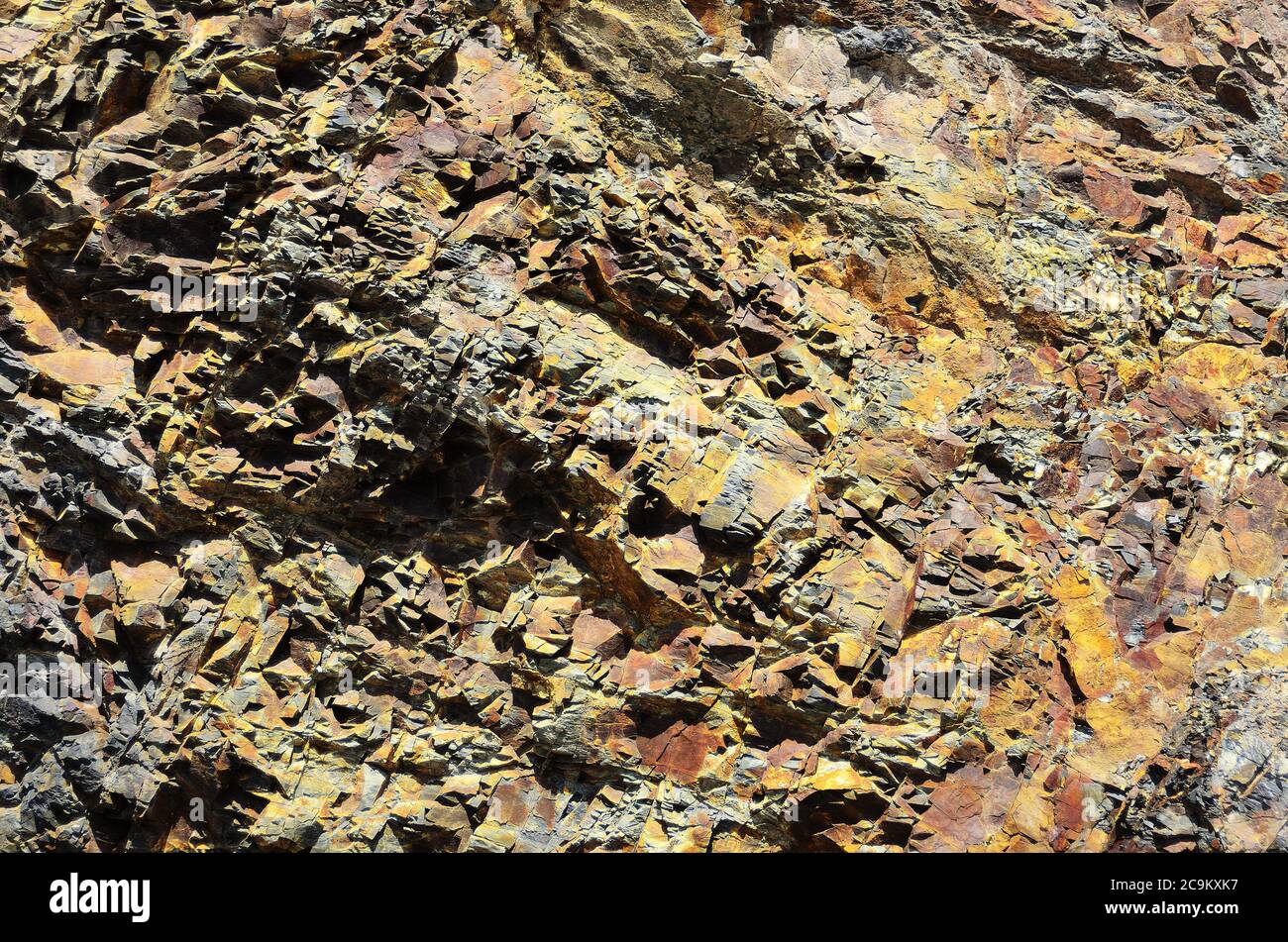 Texture of a relief rock made of yellow and brown stone. Geology Stock ...