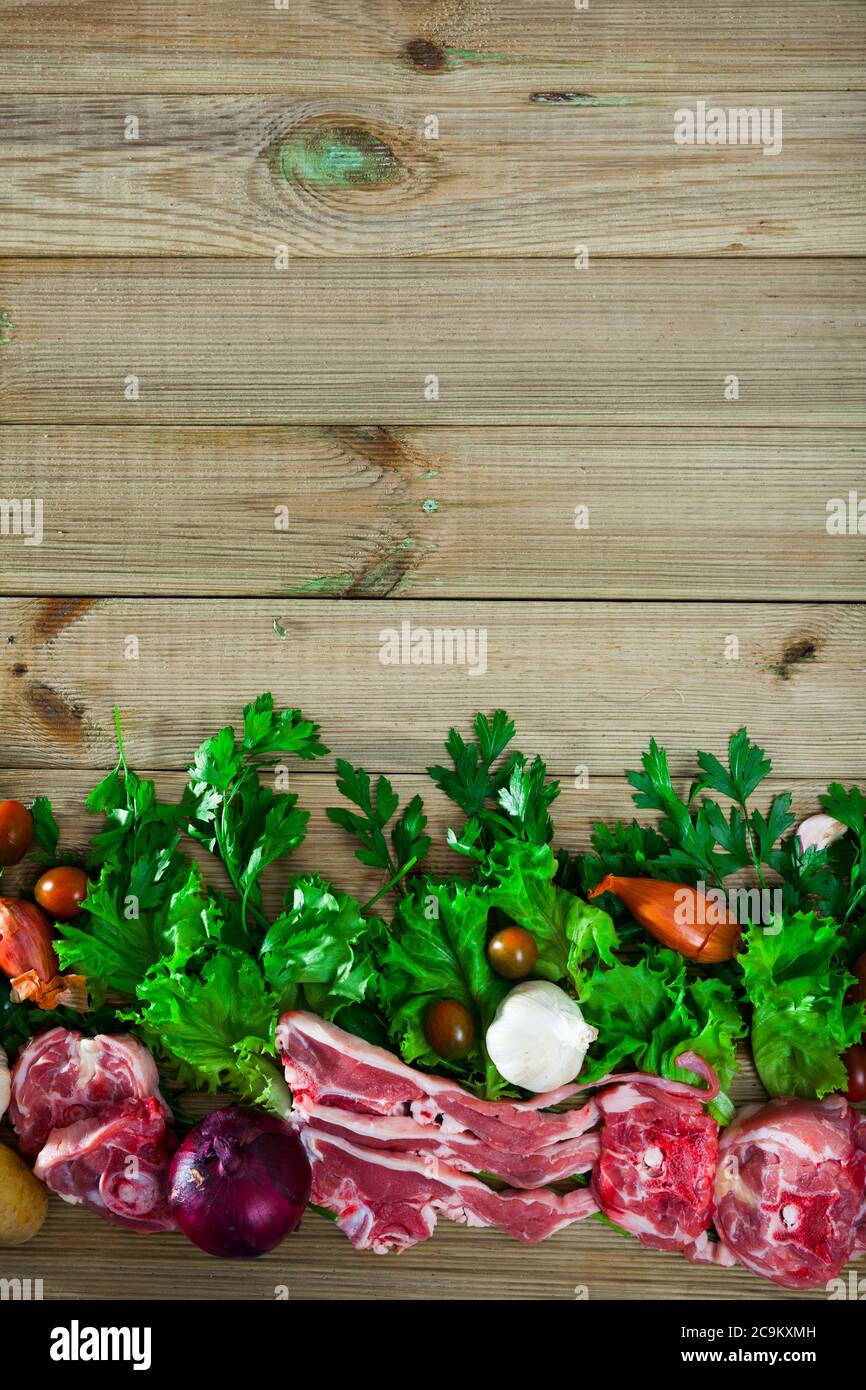Raw mutton and vegetables assortment on natural wooden background ...