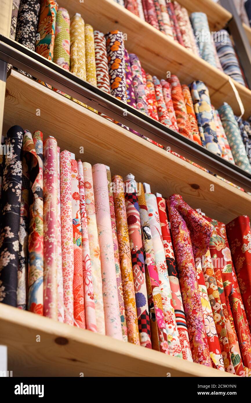 Rolls of fabric and textiles for sale stacked on shelves in shop Stock ...