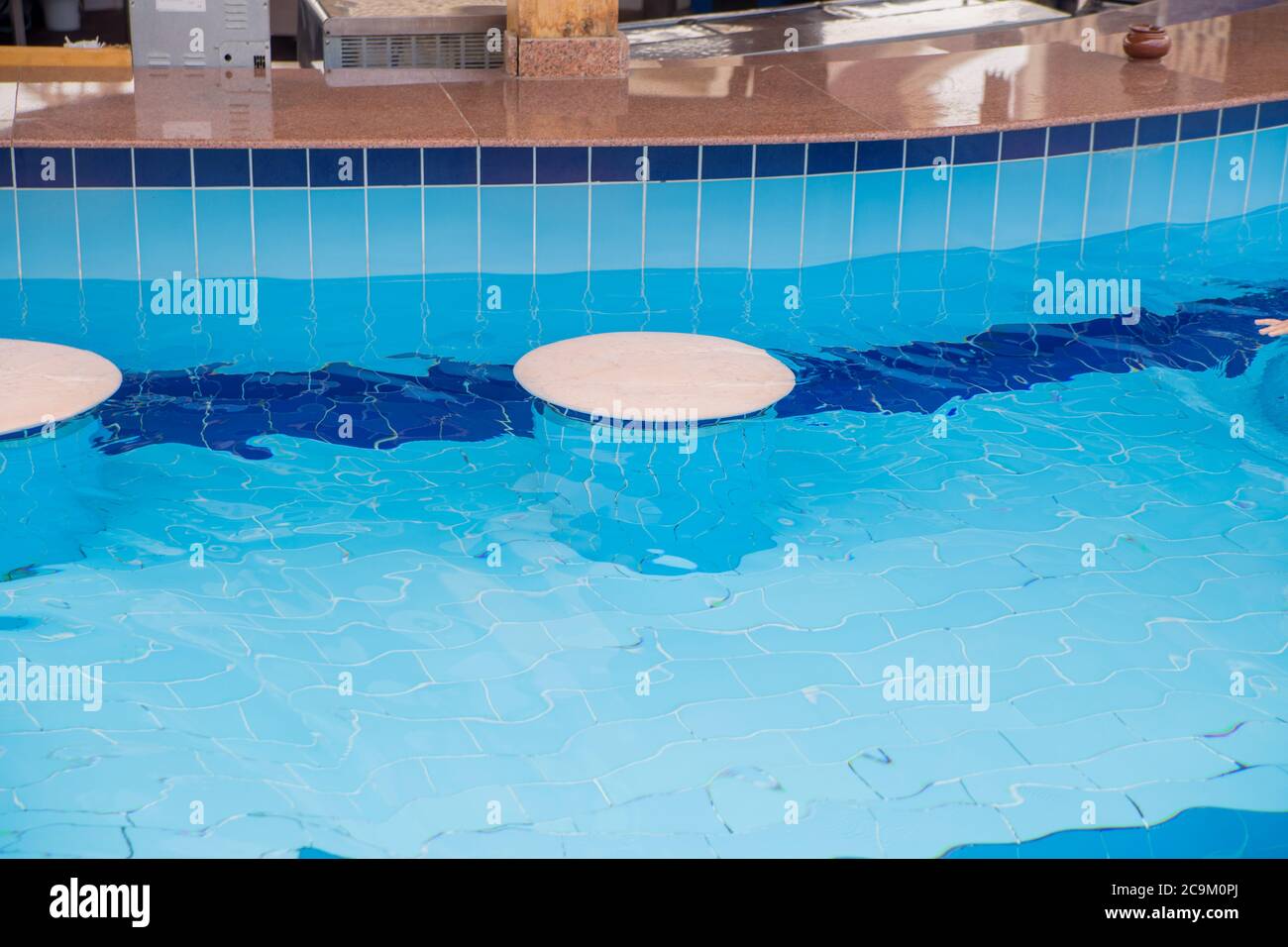 bar counter in pool with clear water and chairs Stock Photo - Alamy