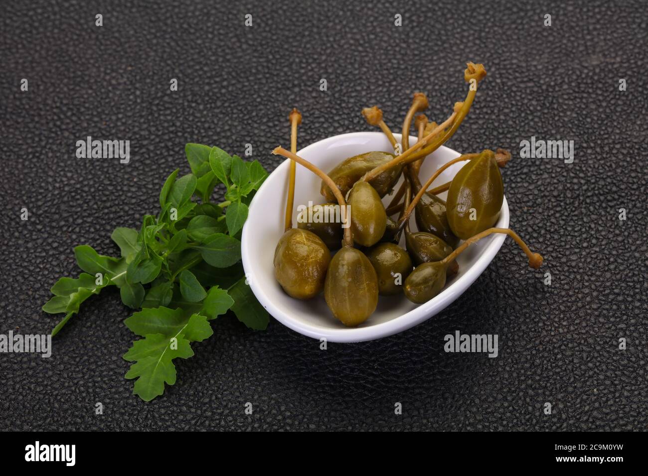 Pickled Capersberries in the bowl with basil Stock Photo - Alamy