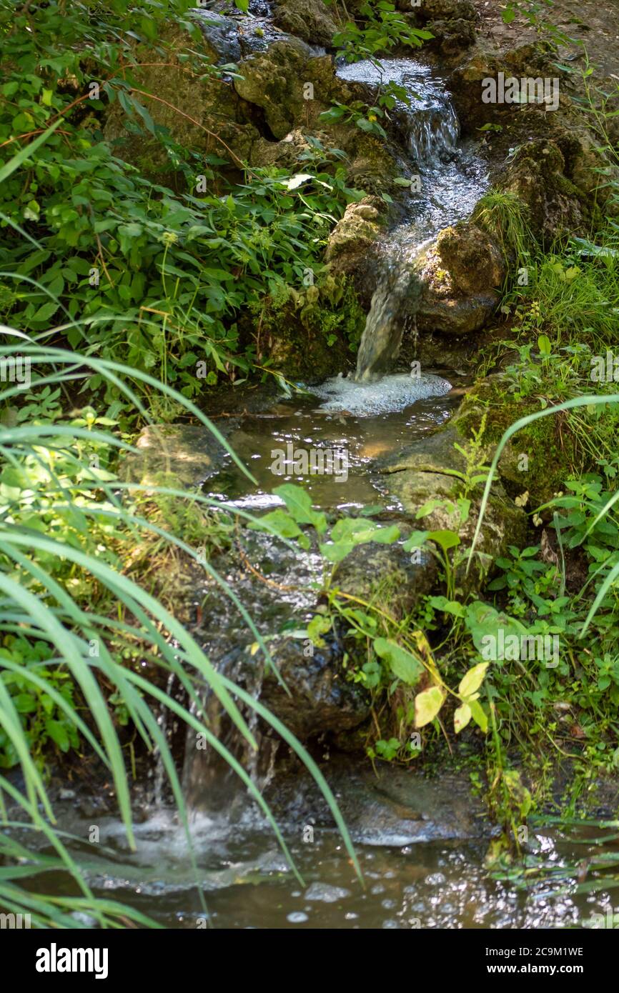 small creek running on a stone way in the middle of the day sun Stock ...