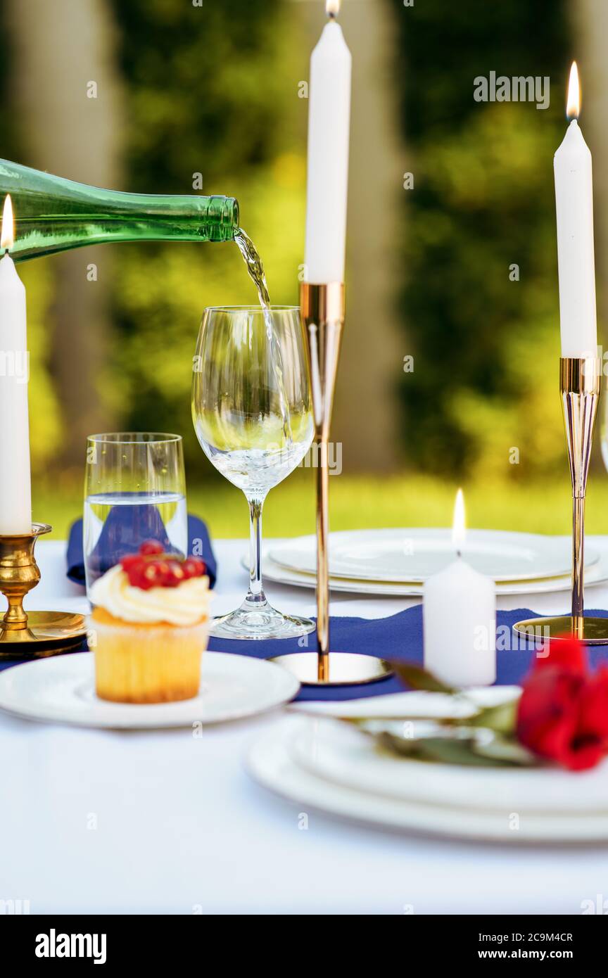 Table setting, wine is poured into a wineglass Stock Photo - Alamy