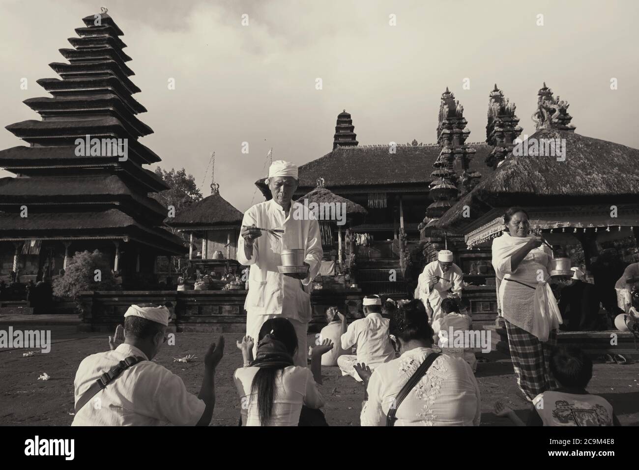 Purifying the spirits: A priest splashing holy water during a Balinese ...