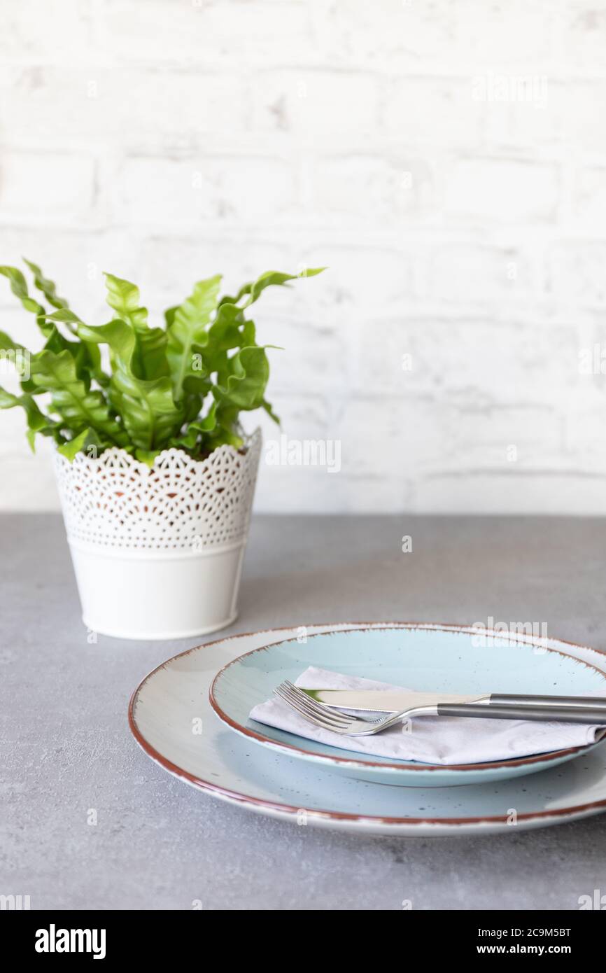 well-laid table with dishes and cutlery and a flowerpot Stock Photo - Alamy