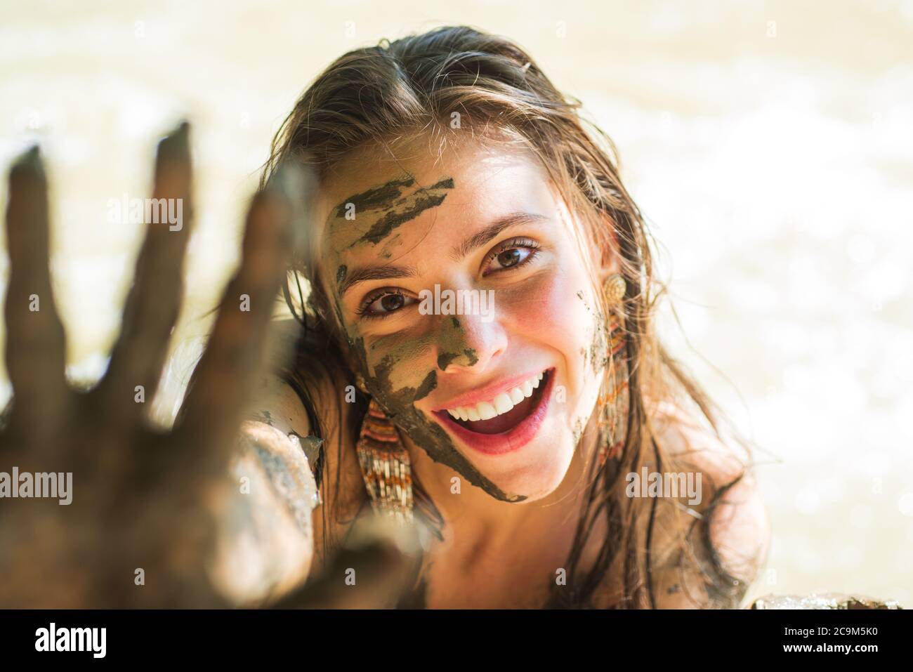 Womans face and hands covered in mud. Mud healthy scrub Stock Photo - Alamy