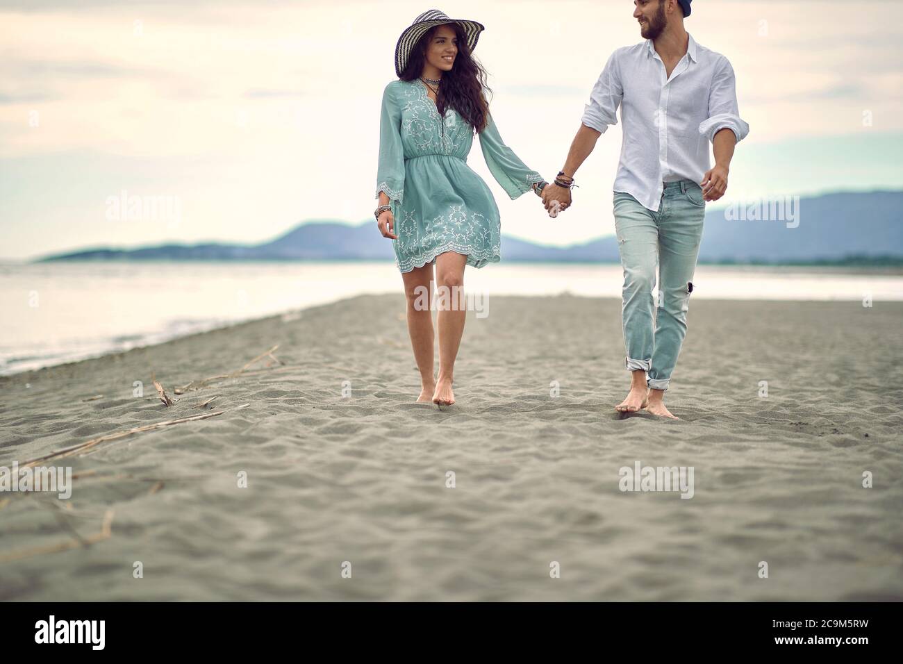 Romantic walk by the sea. Young couple in love having romantic tender ...